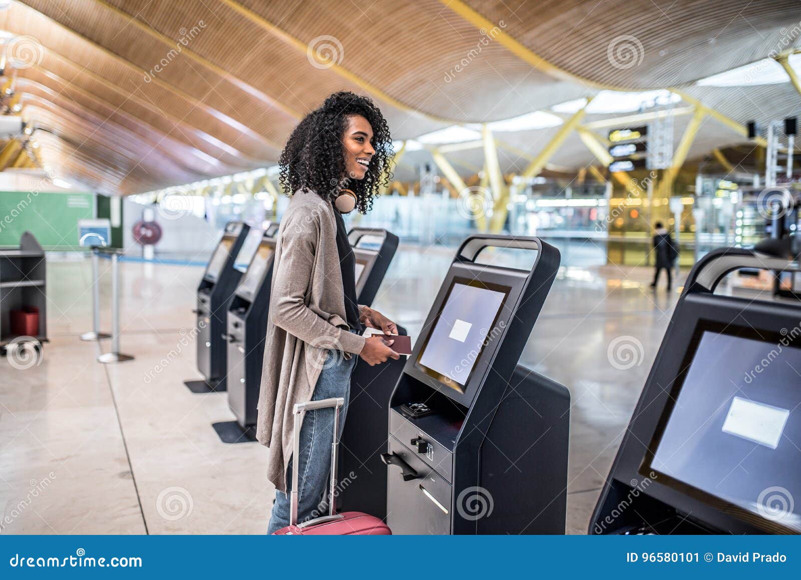 Happy Black Woman Using the Check-in Machine at the Airport Getting the ...