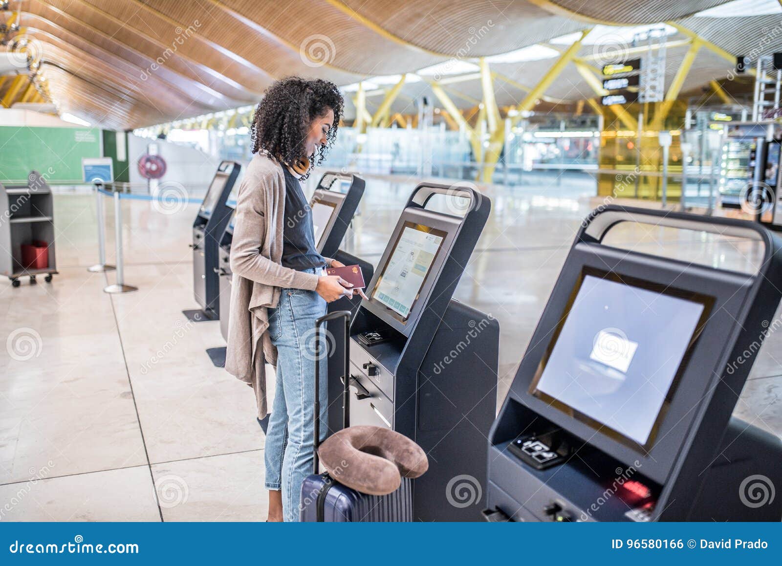 Happy Black Woman Using the Check-in Machine at the Airport Getting the ...