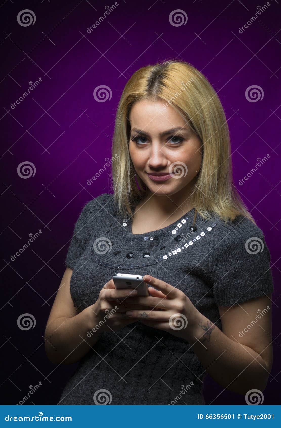 Happy Blonde Haired Model Holding Smartphone on Purple Background Stock ...
