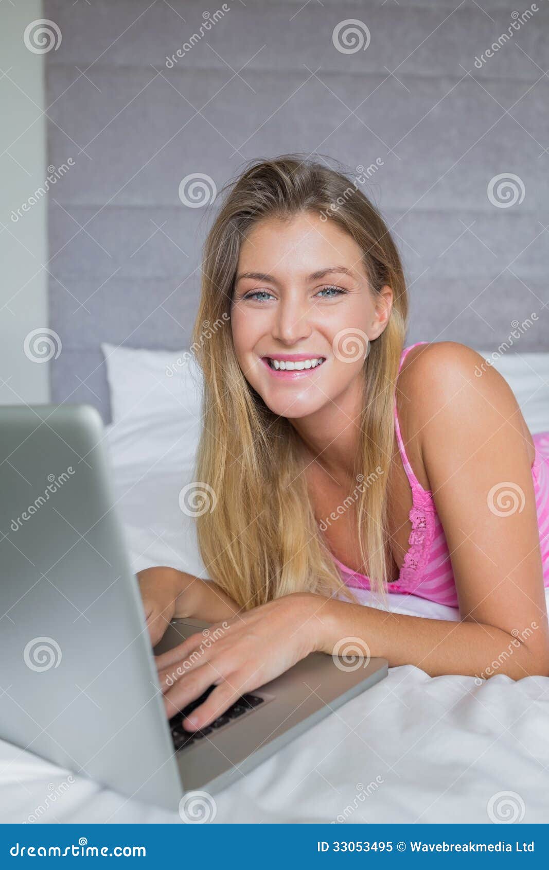 Happy Blonde Lying on Her Bed Using Her Laptop Stock Image - Image of ...