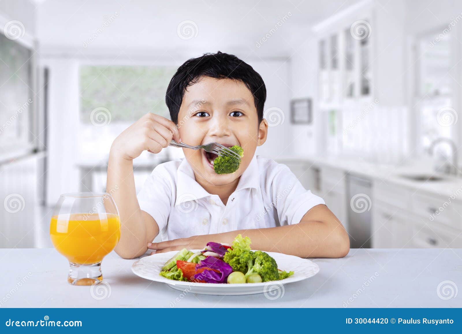 Boy Eating Broccoli at Home Stock Photo - Image of healthy, laughing ...