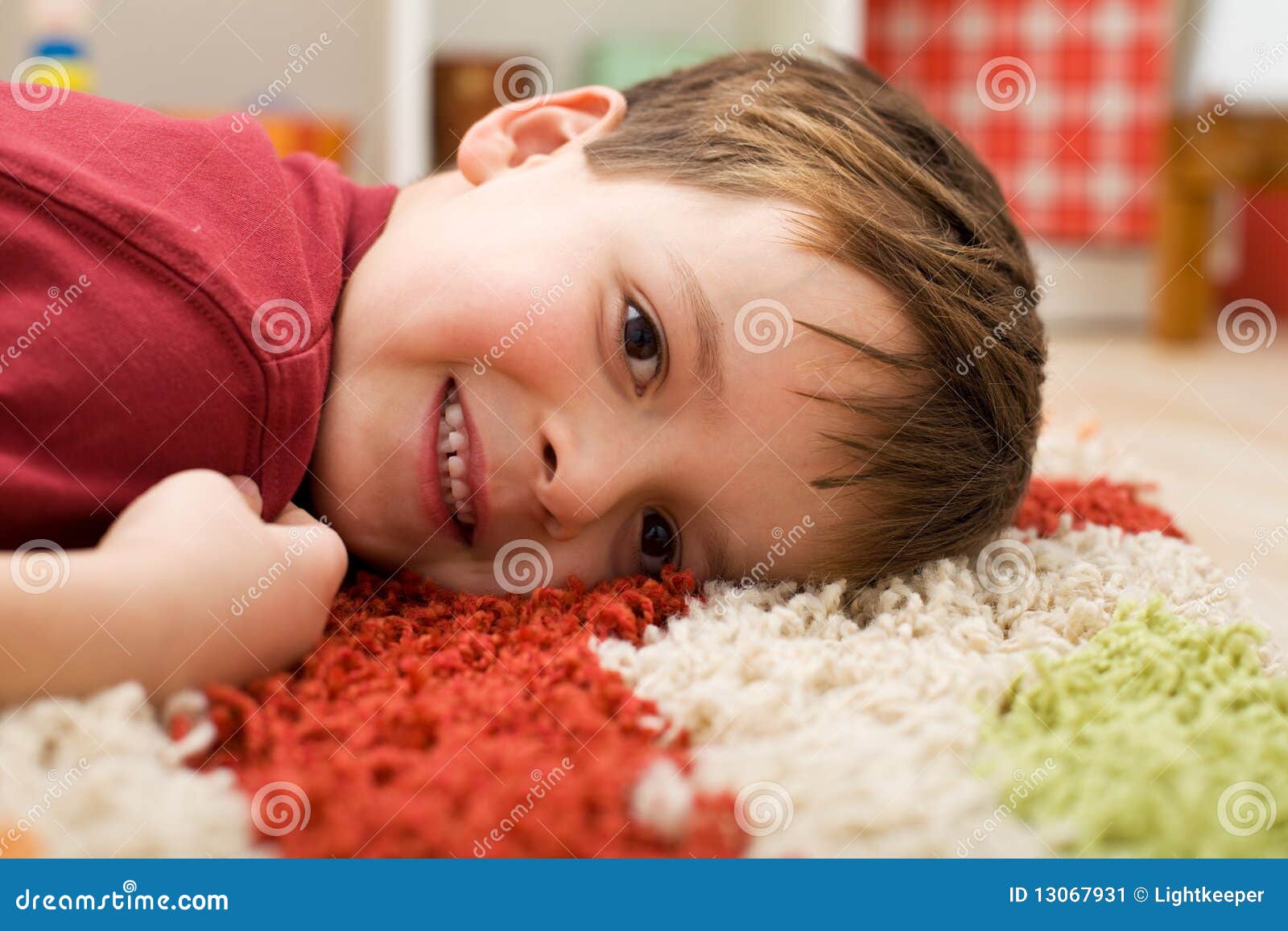 Happy boy laying on a rug stock image. Image of room - 13067931