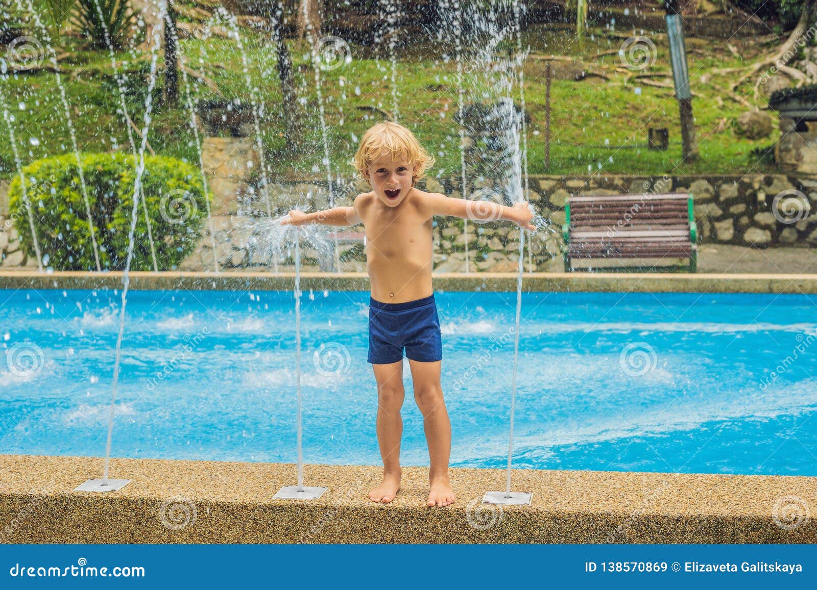 Happy Boy Playing with the Water Fountain in the Pool Stock Image ...