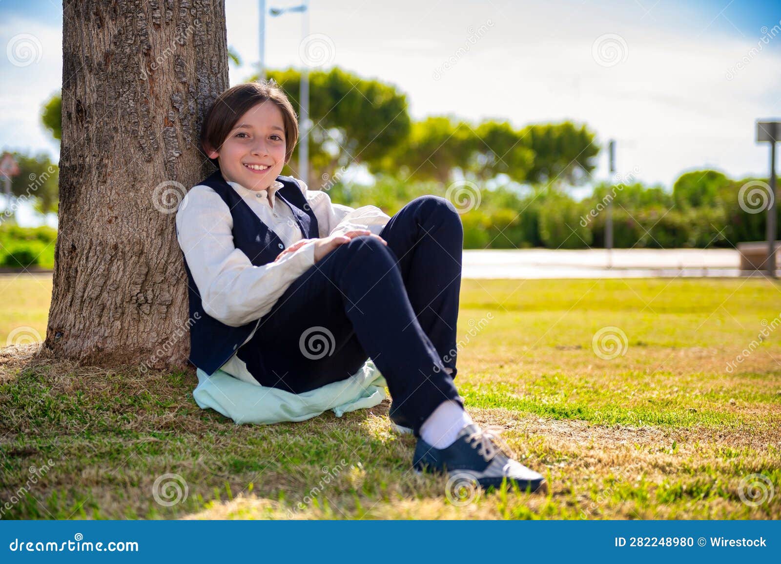 Happy Boy Sitting Outdoors in a Field of Grass Stock Photo - Image of ...