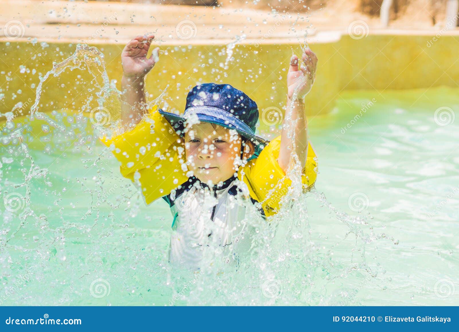 Happy Boy Splashing Water Around Him in Pool Stock Photo - Image of ...