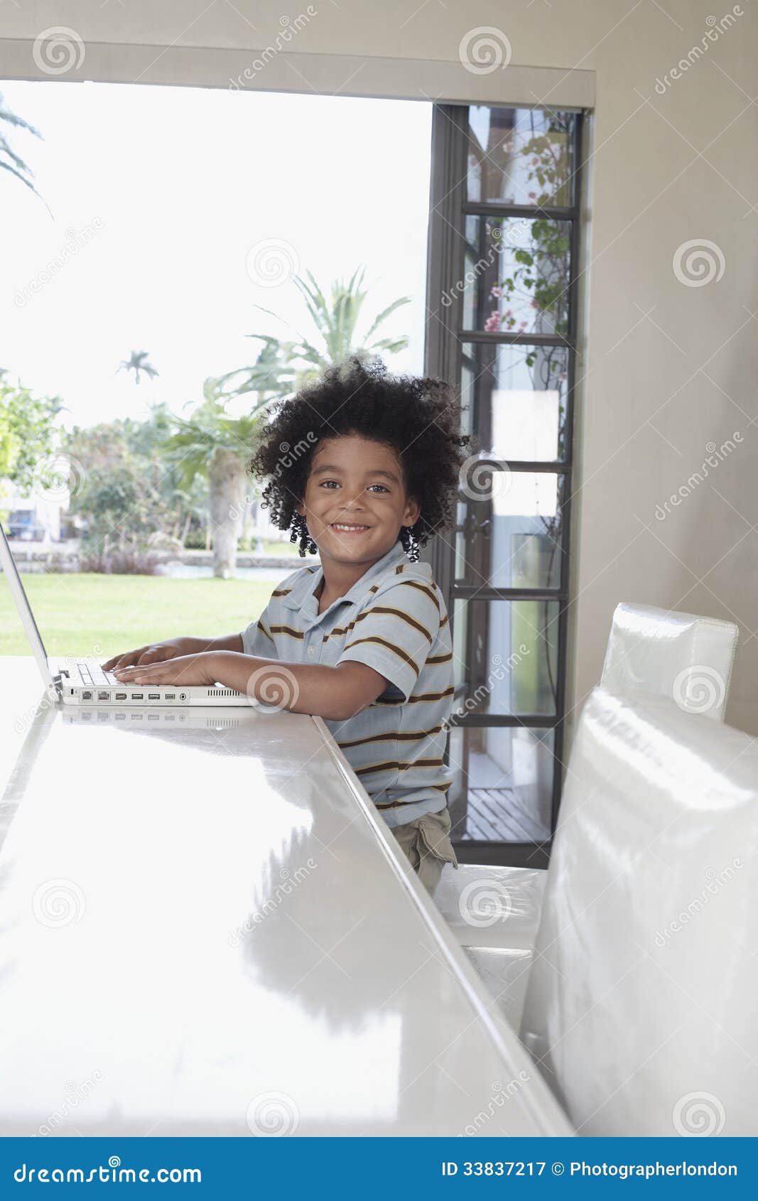 Happy Boy Using Laptop at Dining Table Stock Image - Image of curly ...