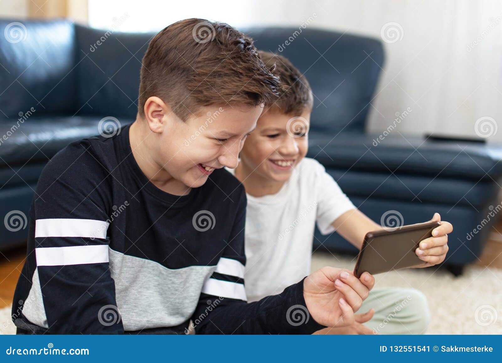 Happy Boys Using Smartphone at Home and Laughing Stock Image - Image of ...