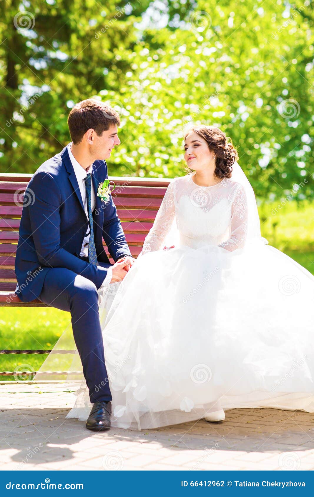 Happy Bride and Groom Sit on the Bench Stock Photo - Image of flowers ...