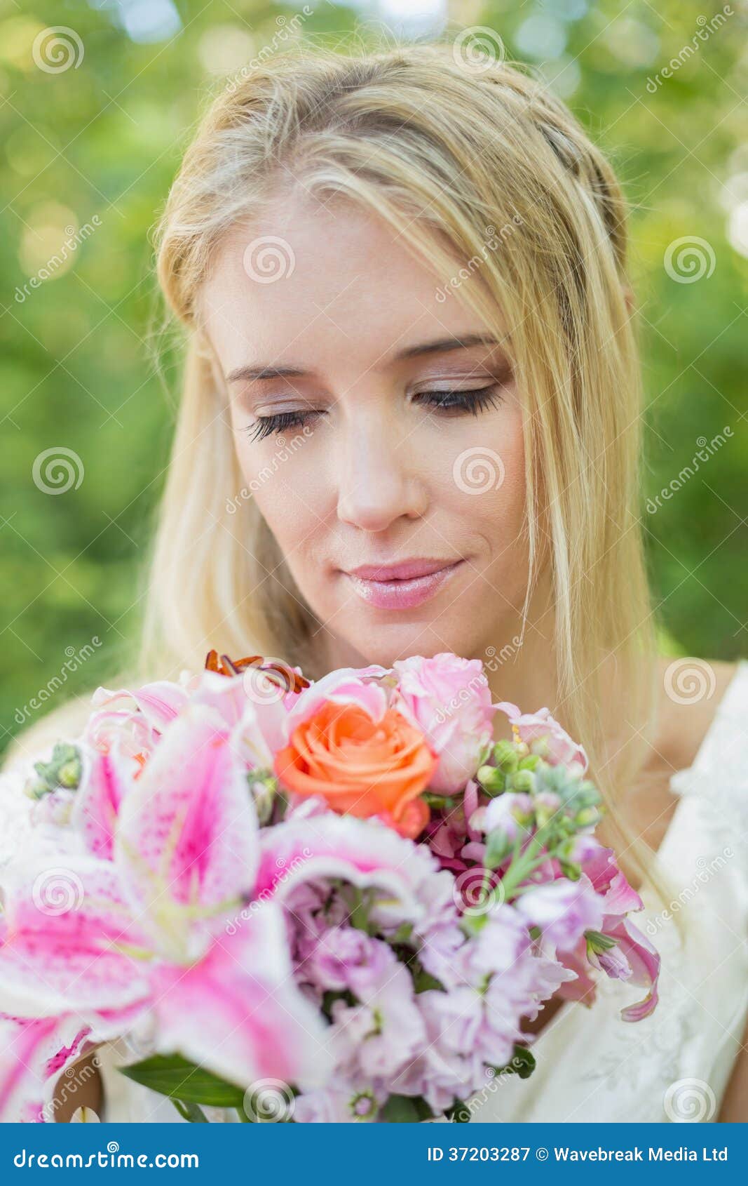Happy Bride Looking at Her Bouquet Stock Image - Image of outdoors ...