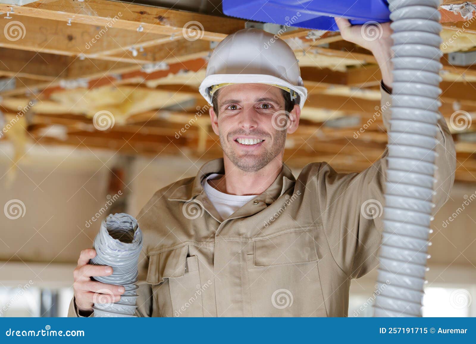 Happy builder with pipes stock image. Image of site - 257191715