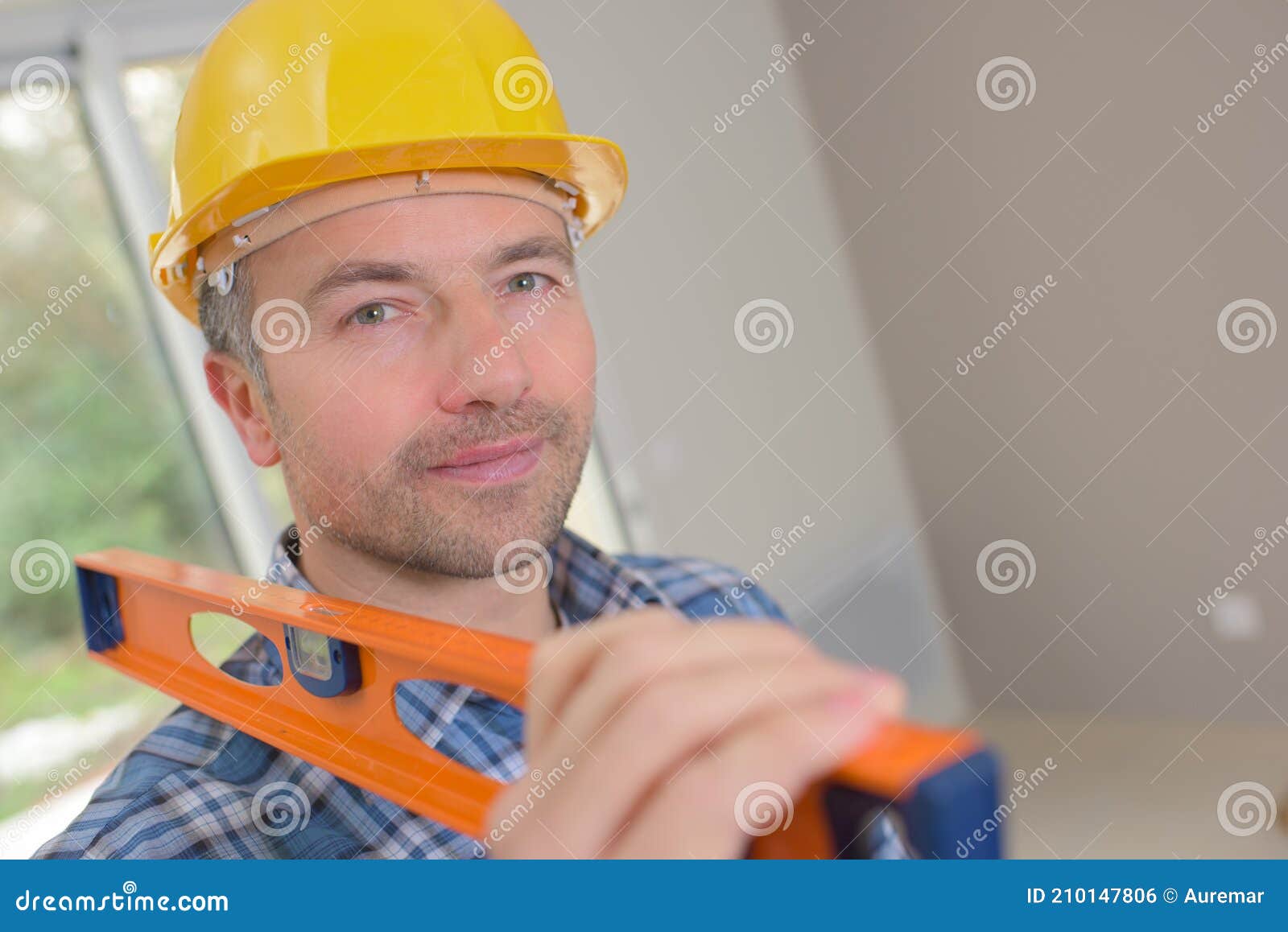 Happy Builder Posing with Spirit Level at Construction Site Stock Photo ...