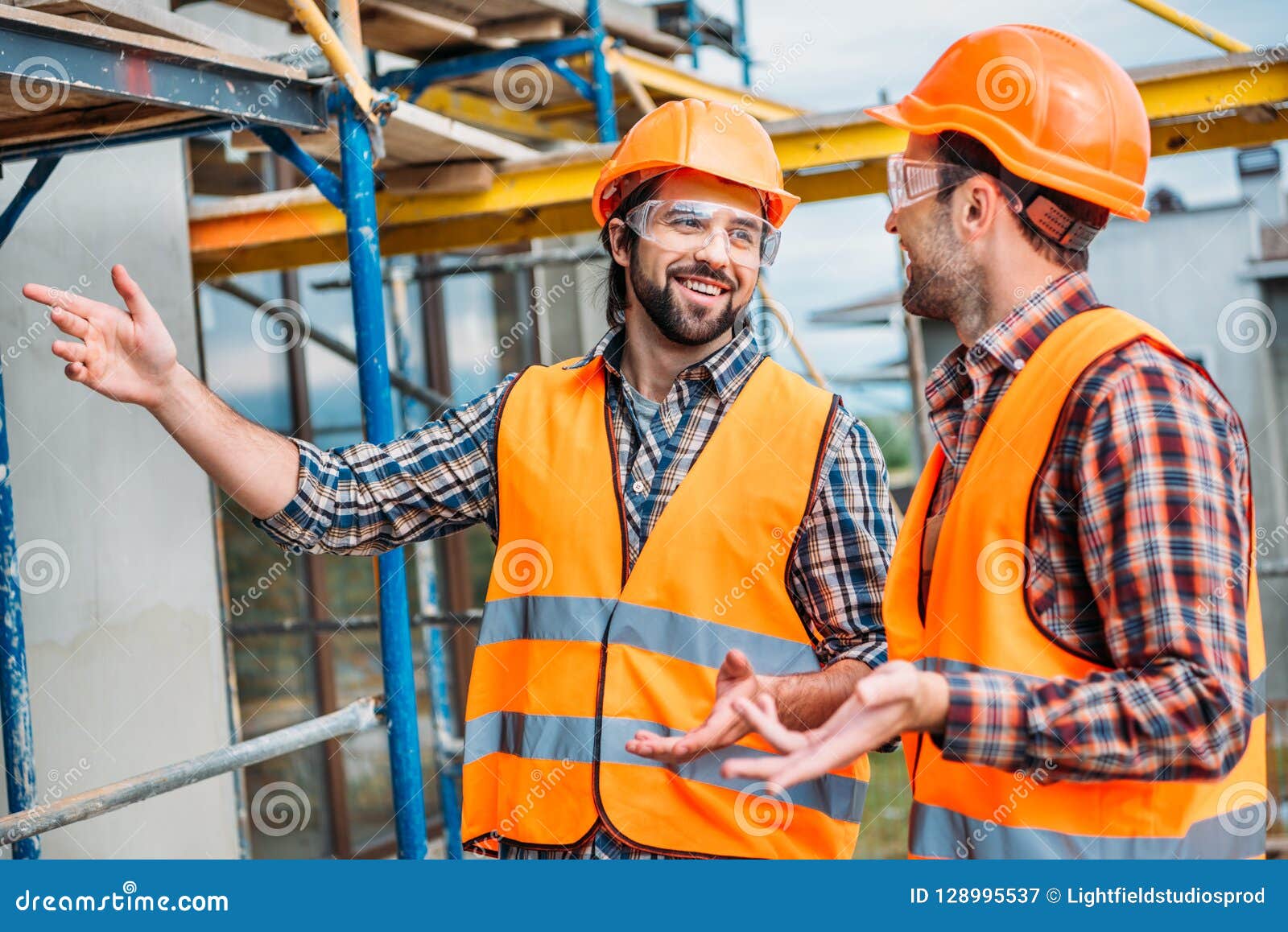 Happy Builders in Reflective Vest and Hard Hat Pointing Stock Image ...