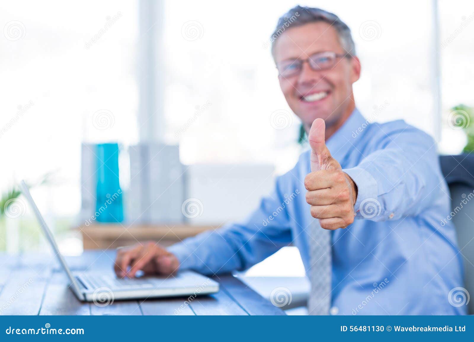 Happy Businessman Using Laptop Computer and Looking at Camera with ...