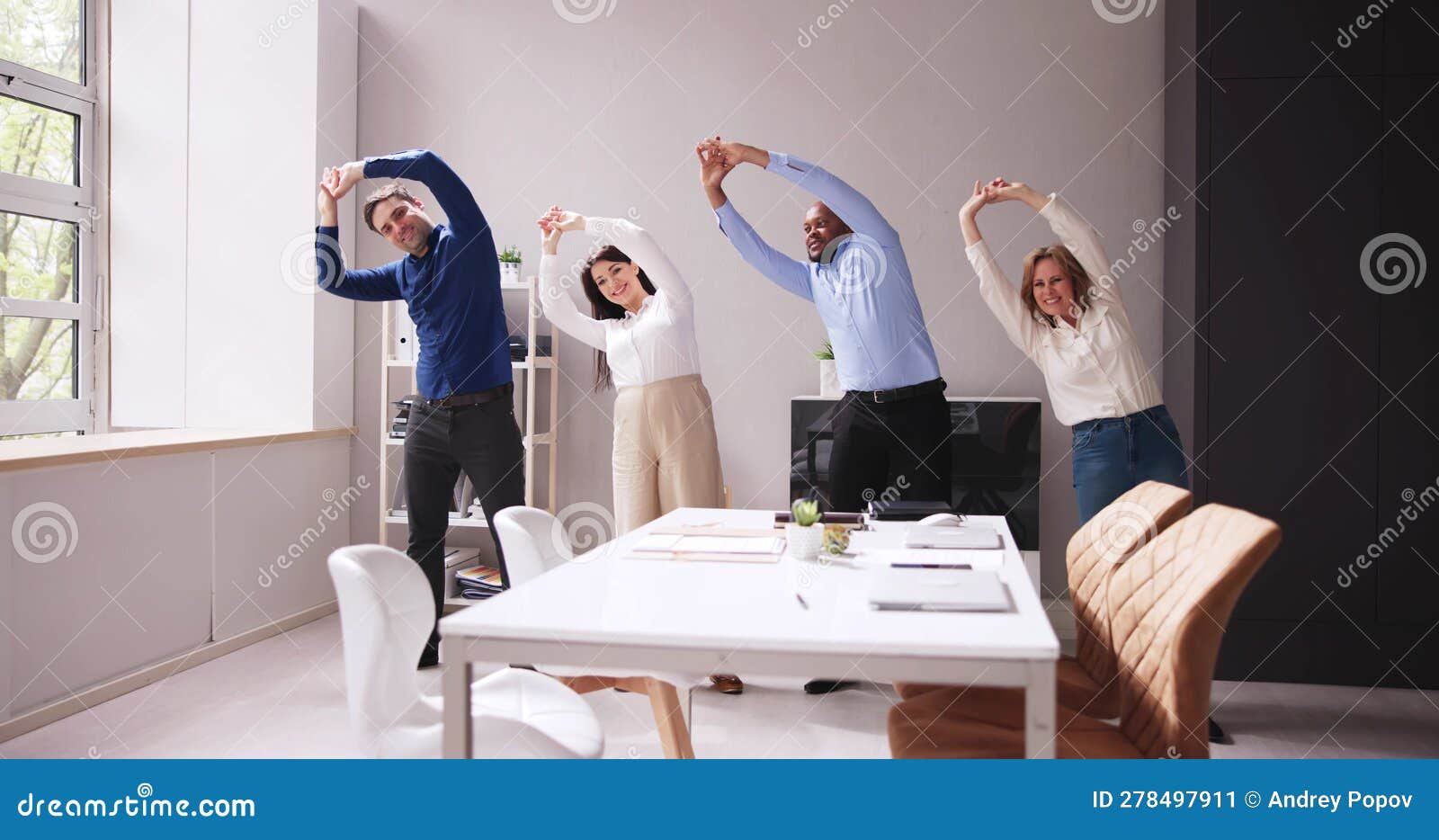 Happy Businesspeople Doing Stretching Exercise Behind Desk Stock Image ...