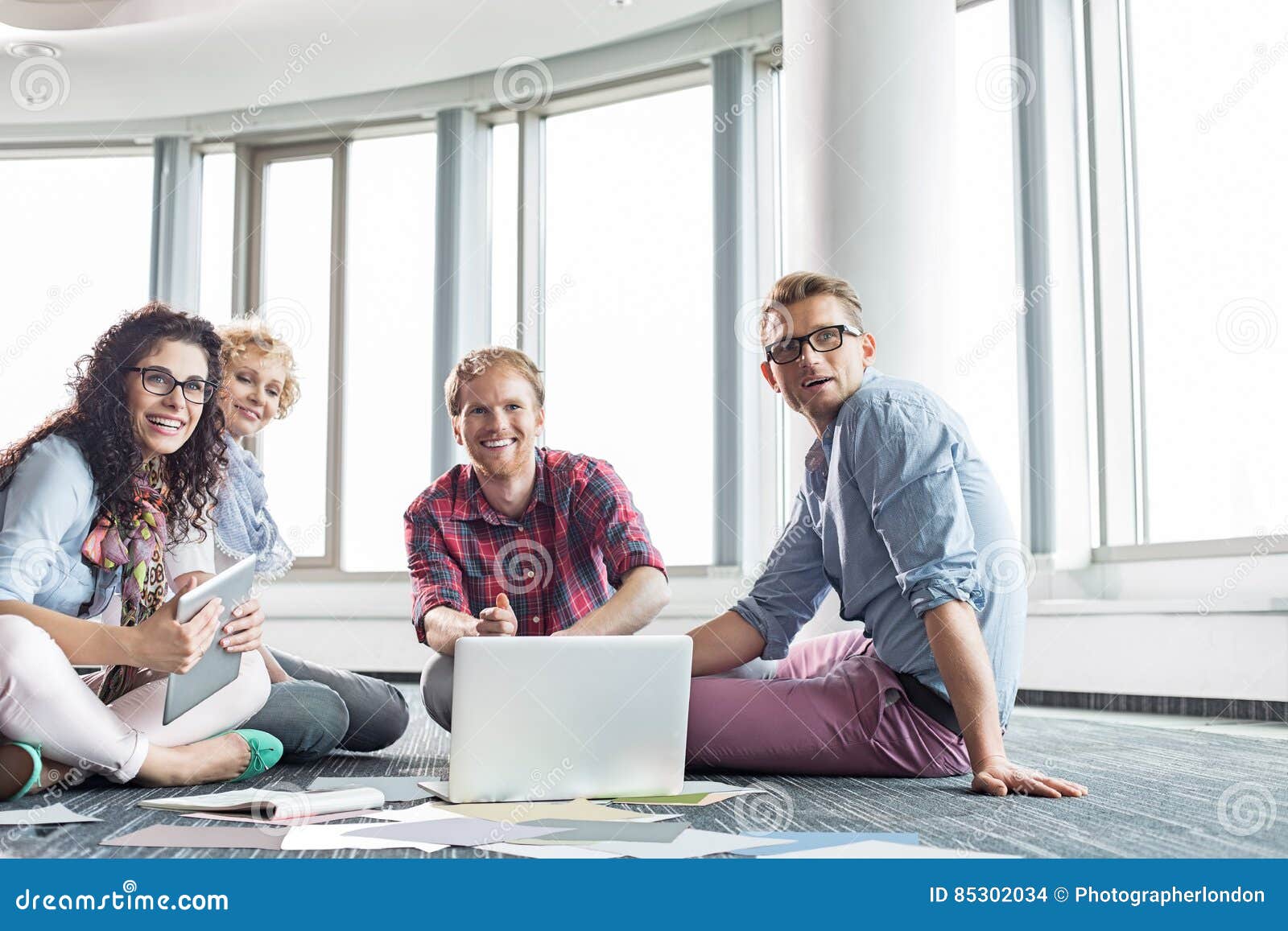 Happy Businesspeople Looking Away while Working on Floor at Creative ...