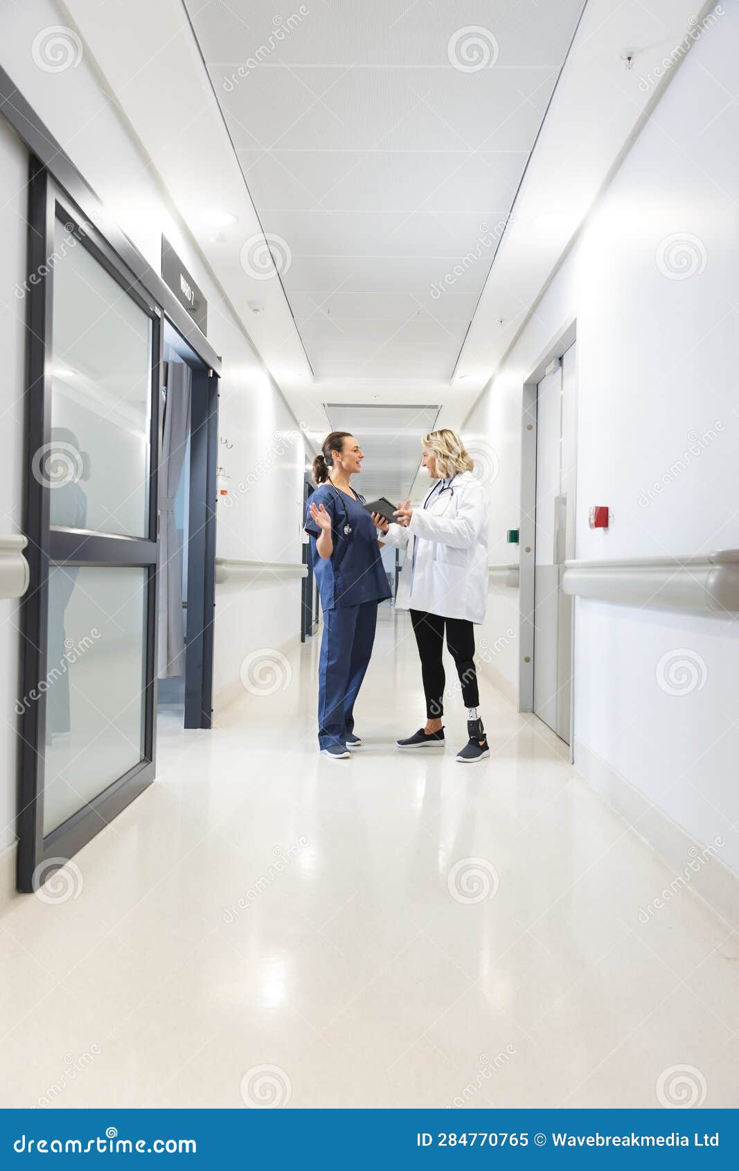 Happy Caucasian Female Doctors with Stethoscopes Using Tablet in ...