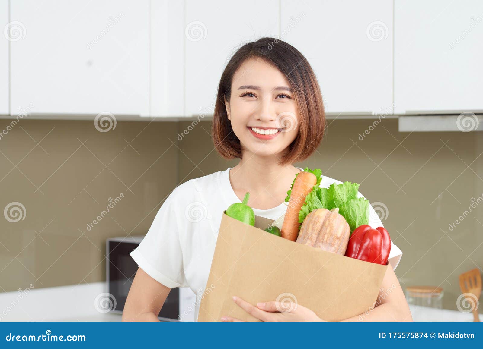 Happy Cheerful Asian Woman Holding Paper Bag Full Of Fresh Products