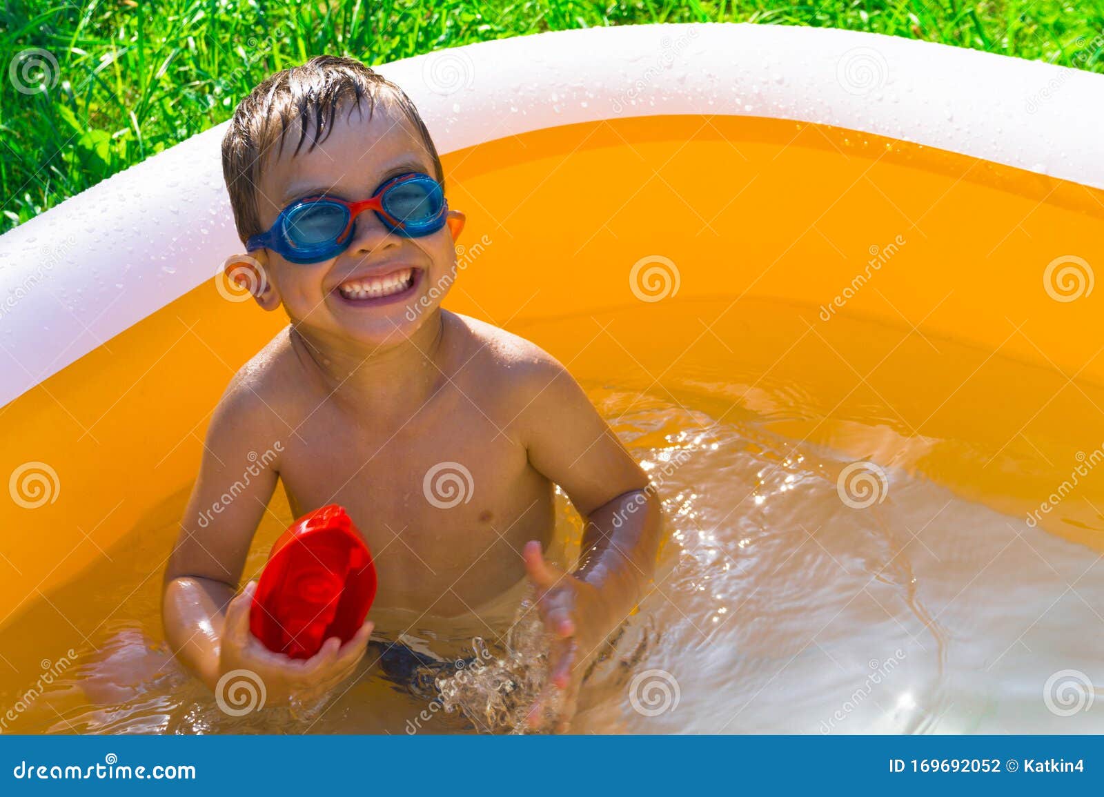 Happy and Cheerful Little Boy in Swimming Goggles Bathes in an ... Happy and Cheerful Little Boy in Swimming Goggles Bathes in an ...