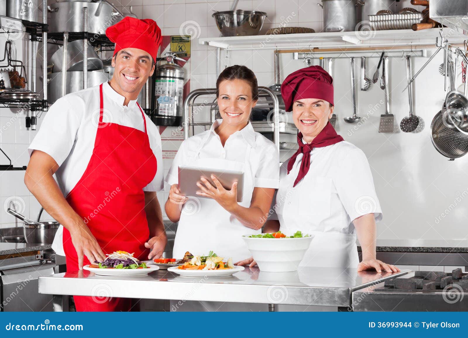 Happy Chefs Using Tablet Computer in Kitchen Stock Photo - Image of ...