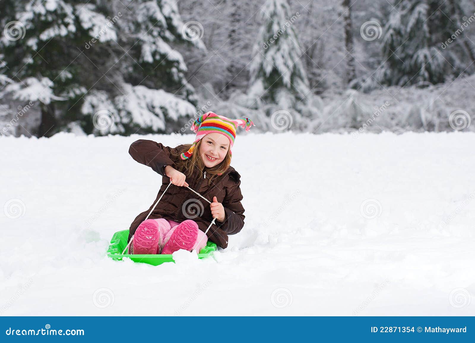Happy child on a snow sled stock photo. Image of smiling - 22871354