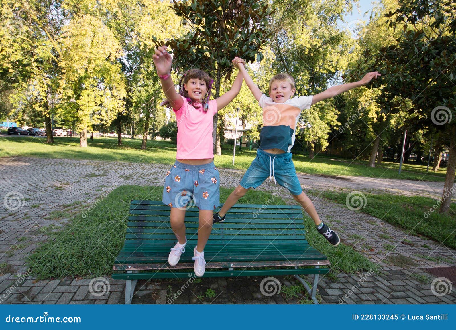Happy Children are Having Fun Jumping from the Bench on the Park Stock ...