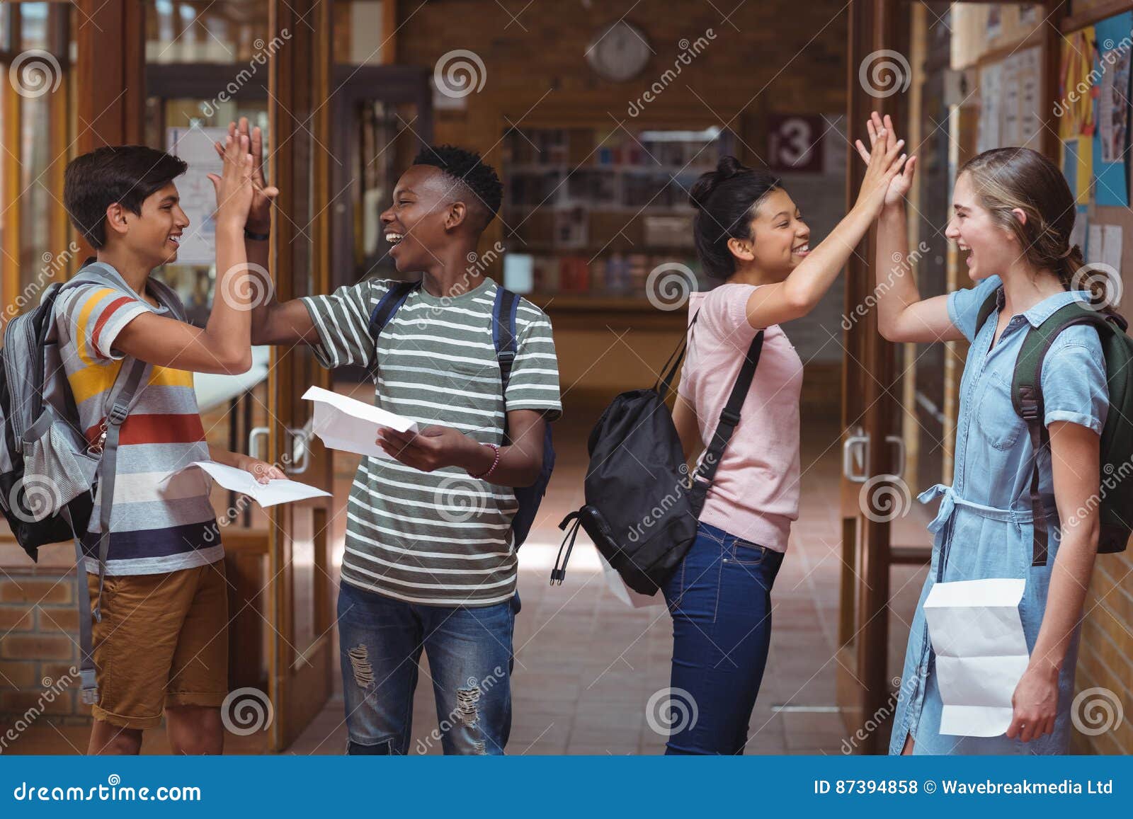 Happy Classmates Giving High Five To Each Other in Corridor Stock Photo ...