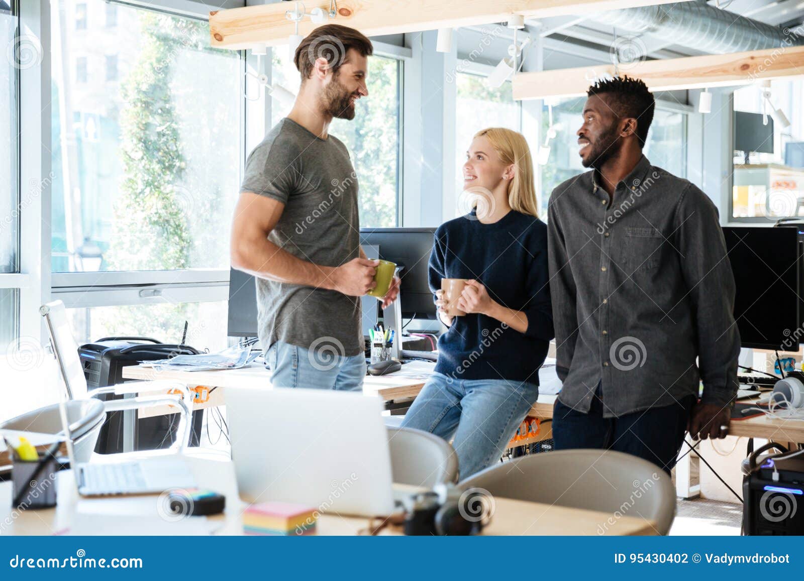 Happy Colleagues Sitting in Office Talking with Each Other. Stock Photo ...