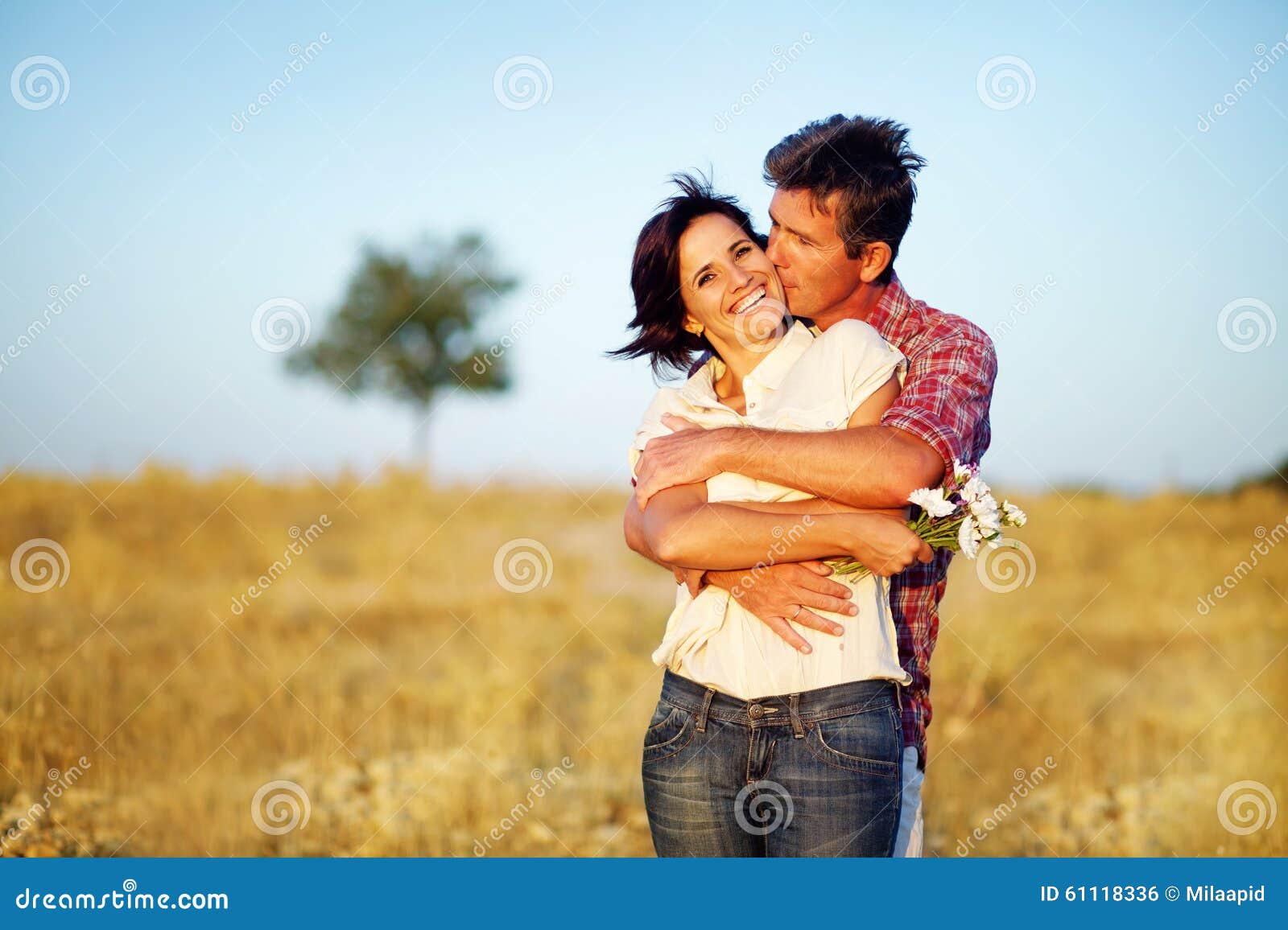 Happy couple in a field stock photo. Image of fashion - 61118336