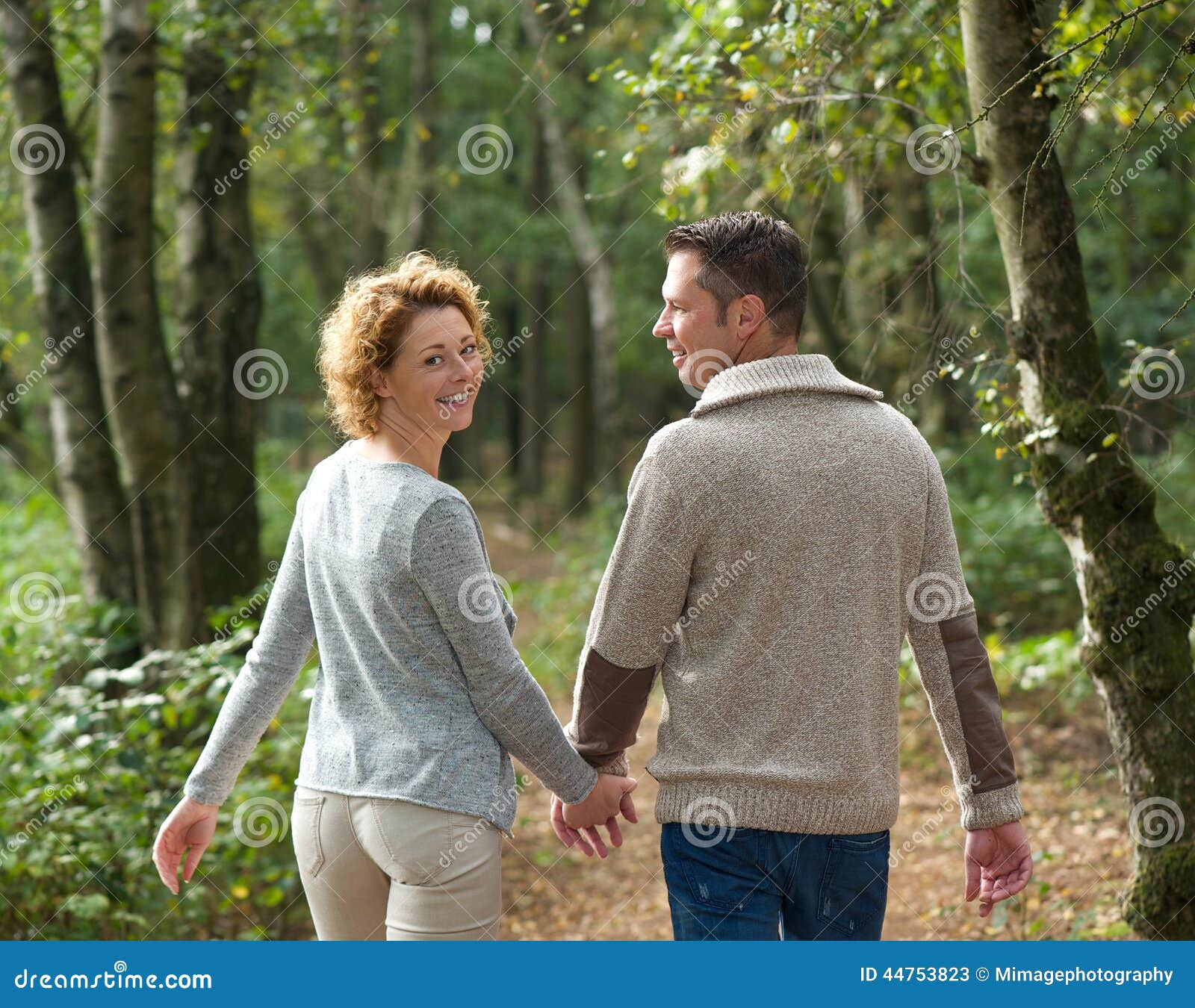Happy Couple Holding Hands and Walking in the Forest Stock Image ...