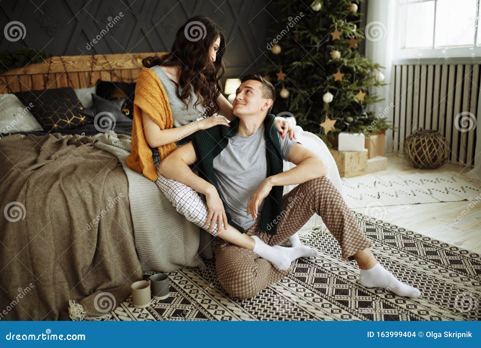 Happy Couple In Love In The Morning On The Bed Near The Christmas Tree