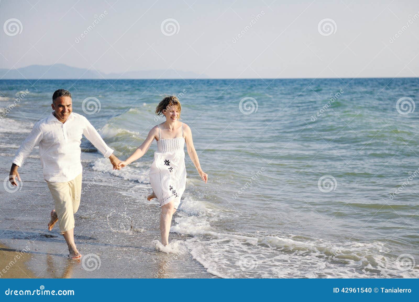 Happy Couple Running through Sea Waves on the Beach Stock Photo - Image ...