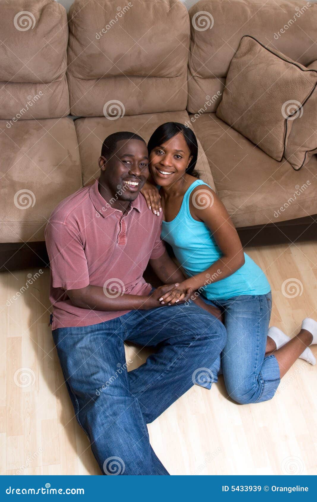 Happy Couple Sitting in Front of Couch - Vertical Stock Image - Image ...