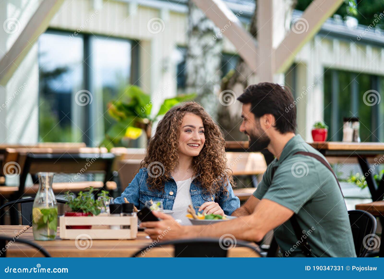Happy Couple Sitting Outdoors on Terrace Restaurant, Talking. Stock ...