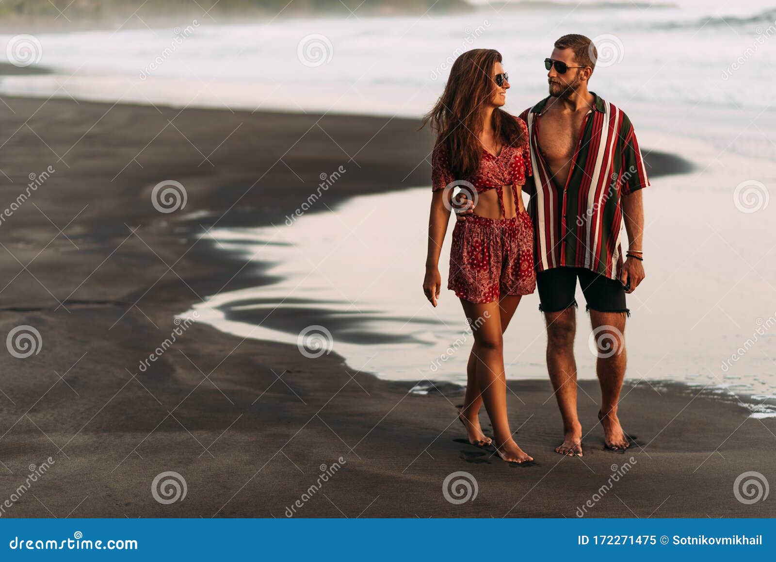 Happy Couple Strolling Along A Sandy Beach Couple In Love At Sunset By