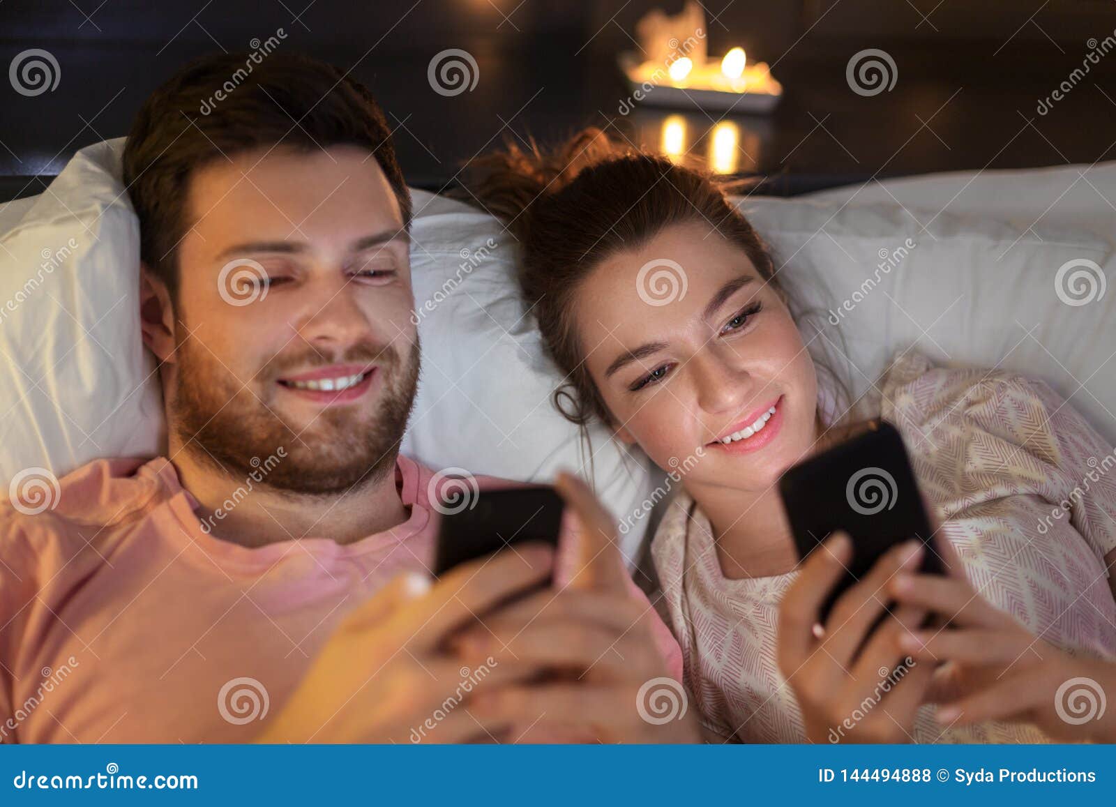 Happy Couple Using Smartphones in Bed at Night Stock Photo - Image of ...