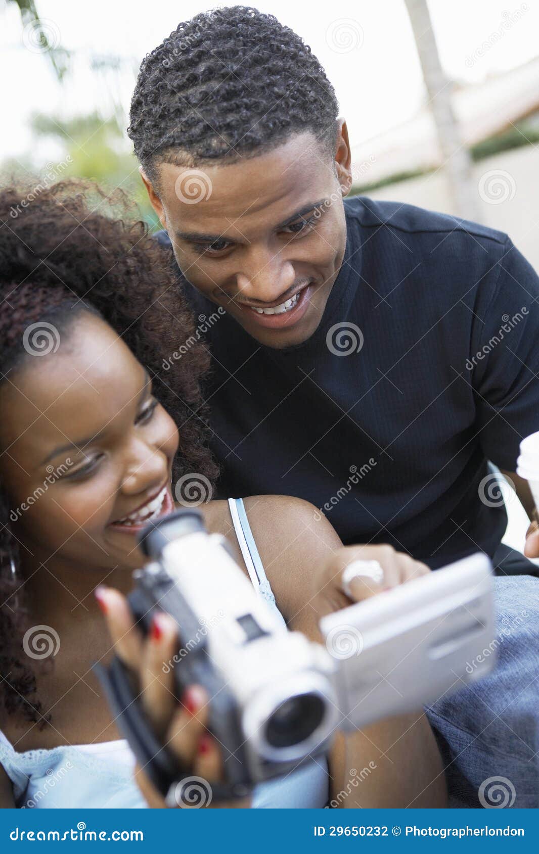Happy Couple Watching a Camcorder Stock Photo - Image of smile, couple ...