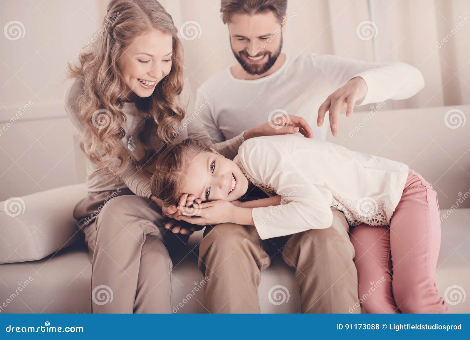 Happy Daughter Lying on Parents Lap and Looking at Camera Stock Photo ...