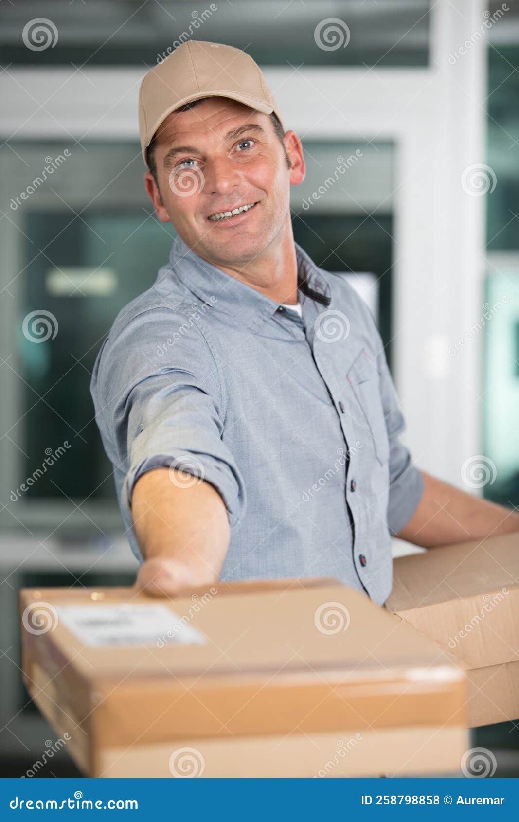 Happy Delivery Man Giving Parcel To Camera Stock Photo - Image of ...