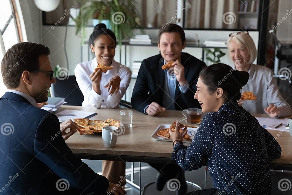 Happy Diverse Coworkers Enjoying Pizza Party At Office Meeting Table