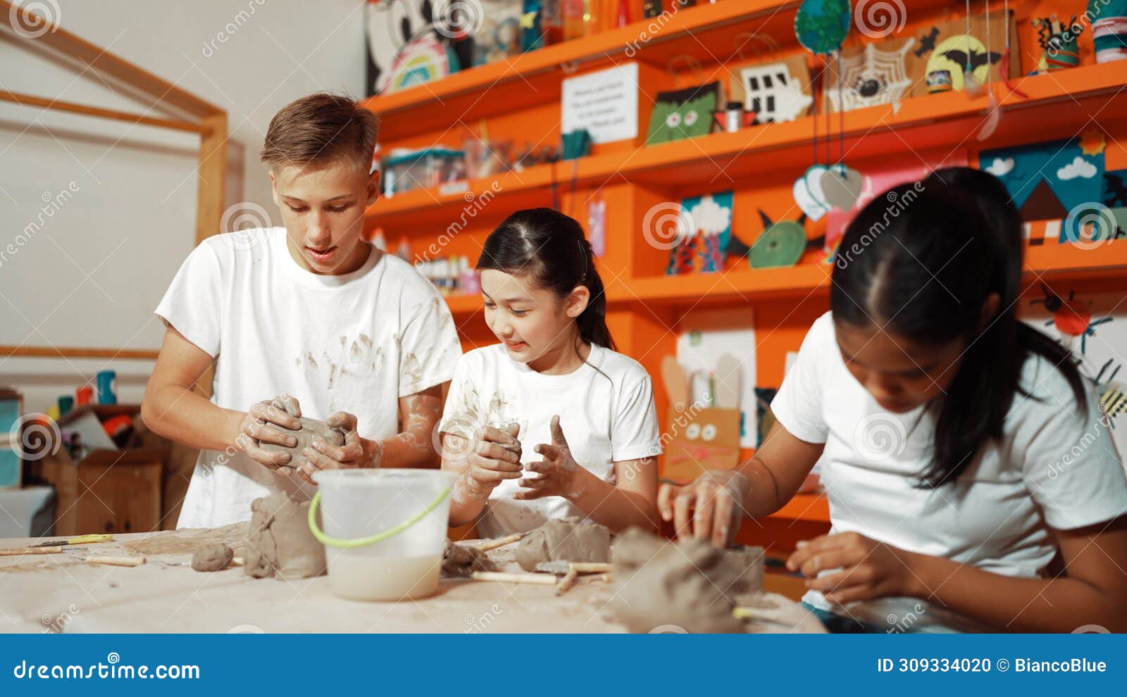 Happy Diverse Highschool Student Modeling Clay at Pottery Workshop ...