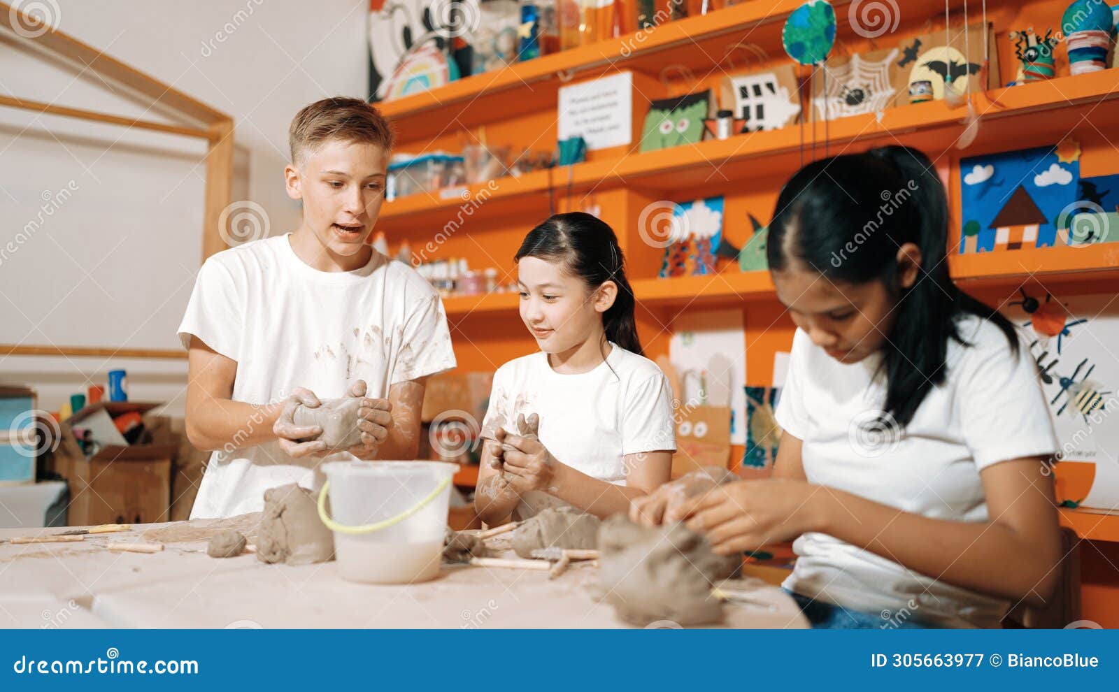 Happy Diverse Highschool Student Modeling Clay at Pottery Workshop ...