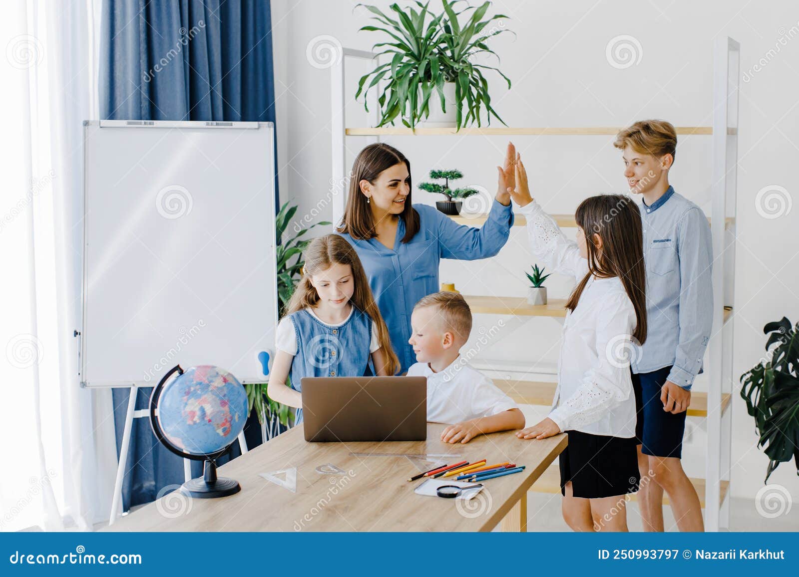 Portrait of Children and Teacher Looking at Laptop in the Classroom ...
