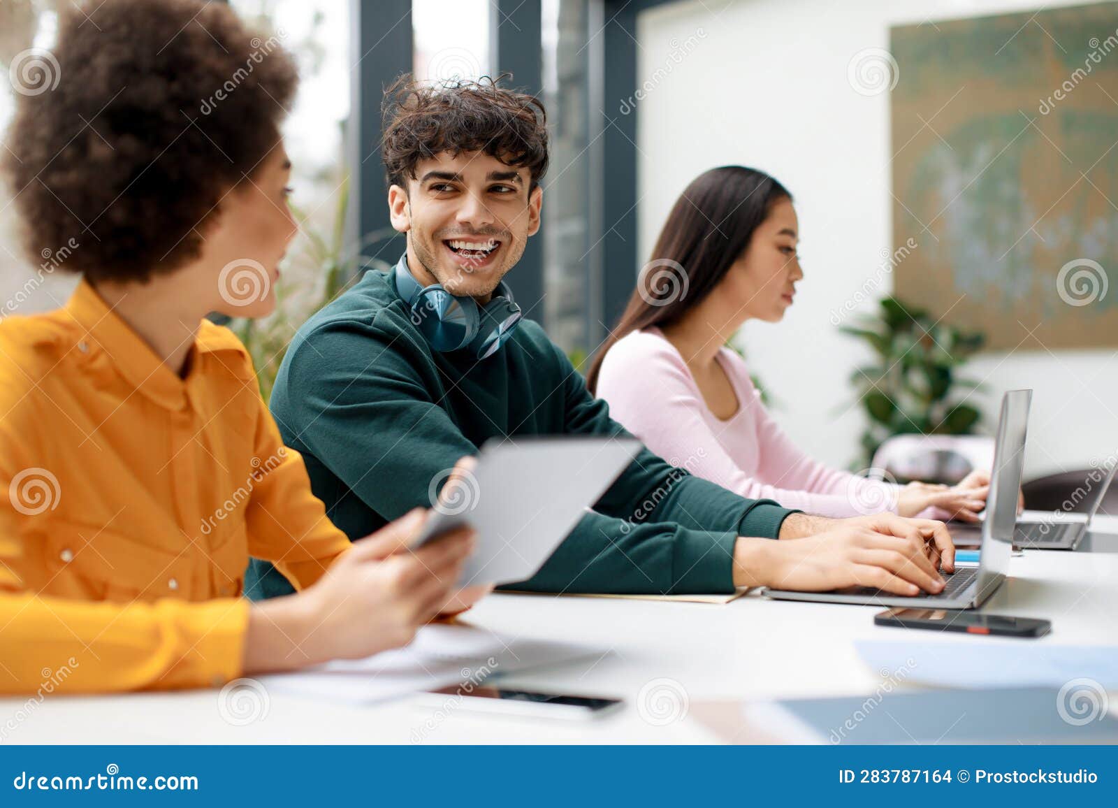 Happy Diverse Students Sitting in Classroom and Communicating, Using ...