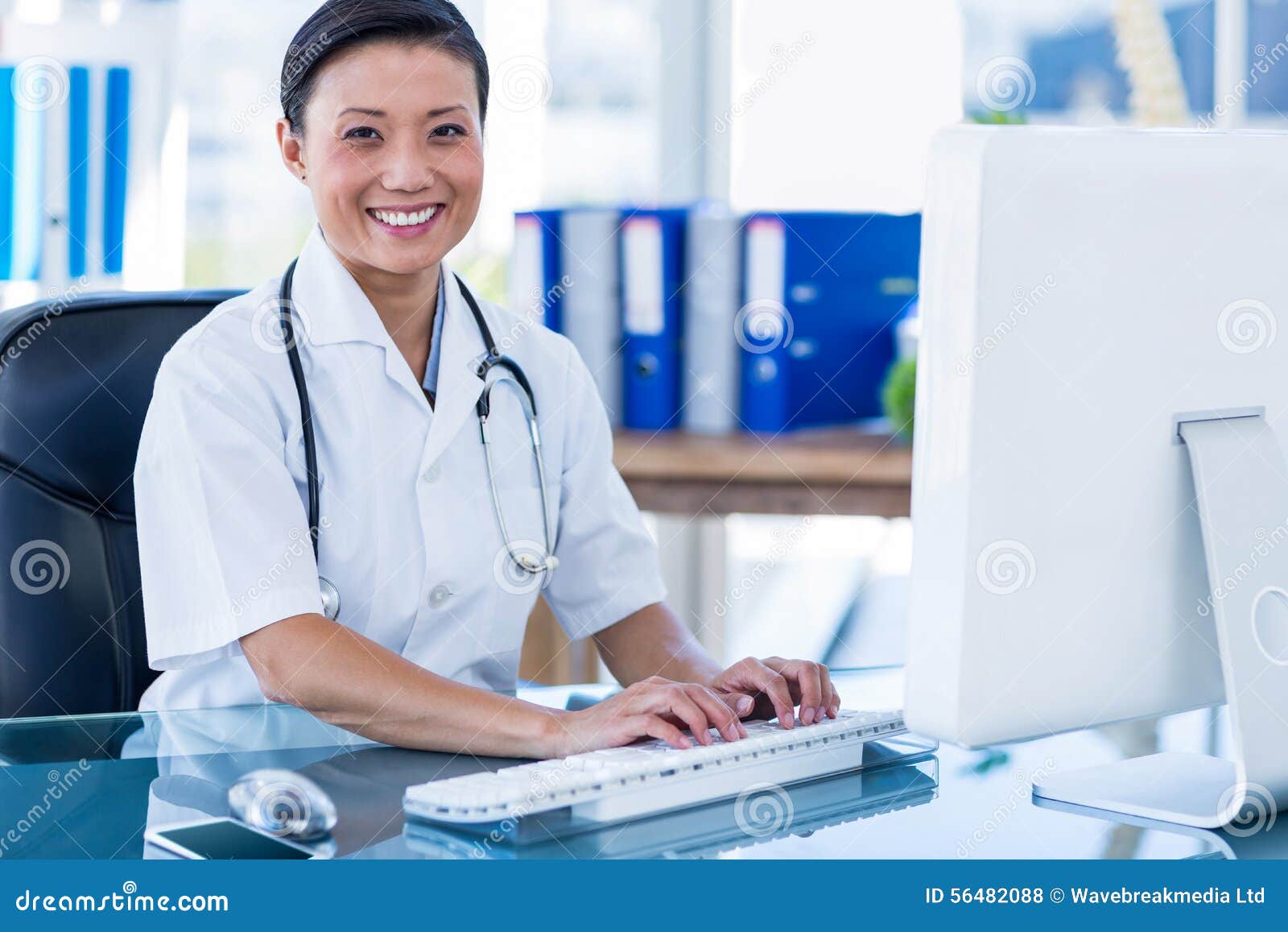 Happy Doctor Using Her Computer and Looking at Camera Stock Photo ... Happy Doctor Using Her Computer and Looking at Camera Stock Photo ...