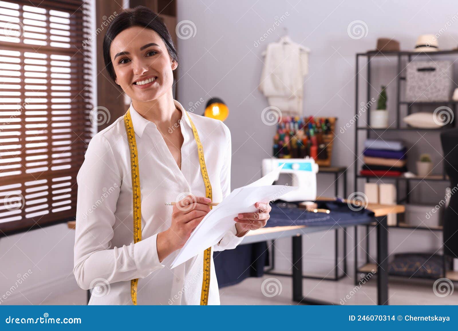 Happy Dressmaker with Measuring Tape and Sketches in Workshop Stock ...