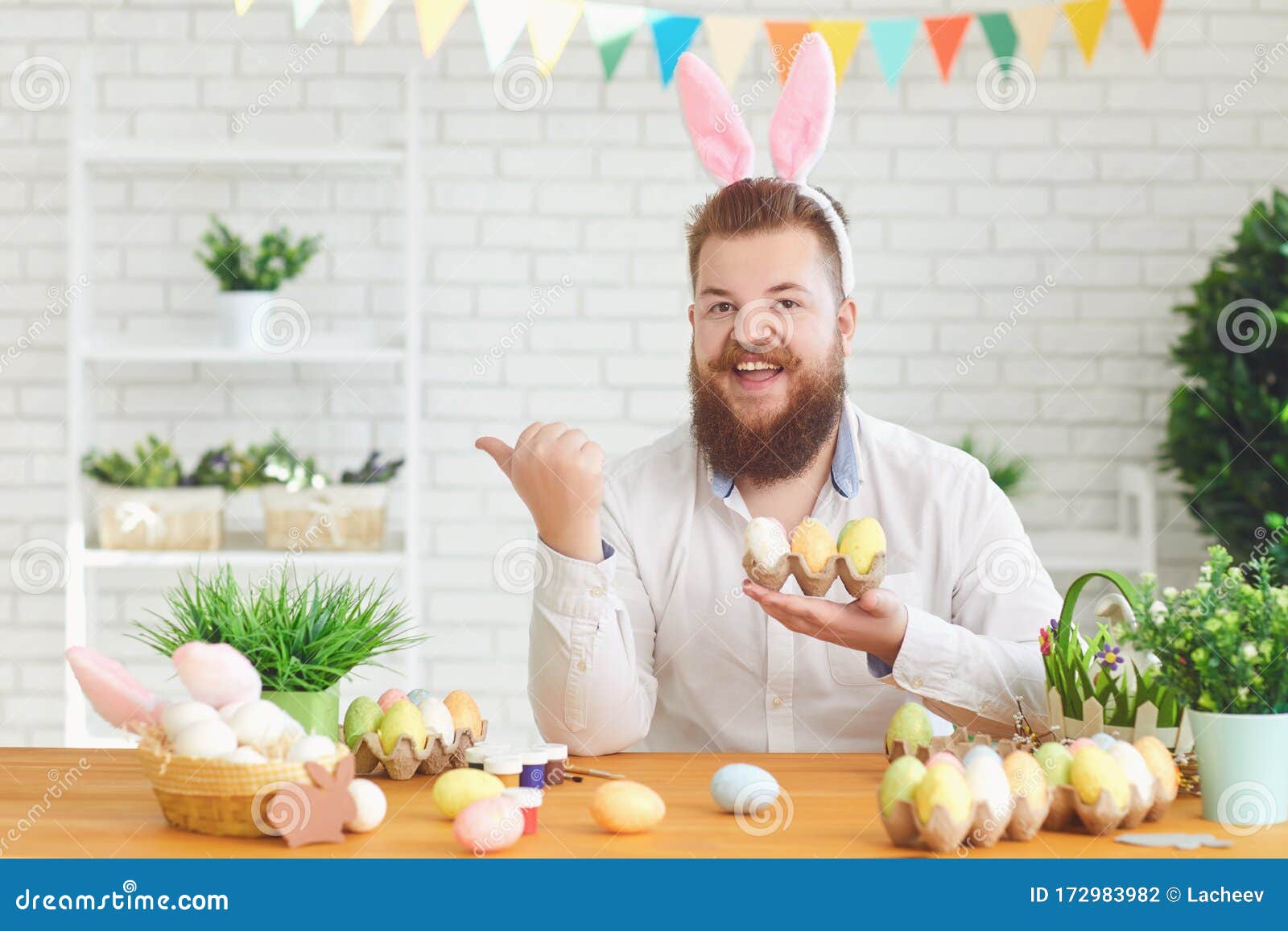 Happy Easter.a Funny Fat Man Decorates Eggs while Sitting at a Table ...