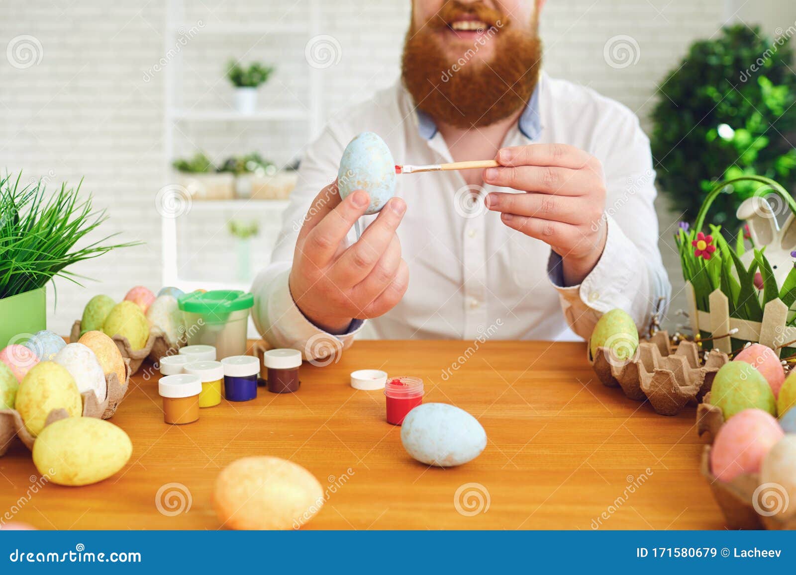 Happy Easter. the Hands of a Bearded Fat Man Decorate Eggs at a Table ...