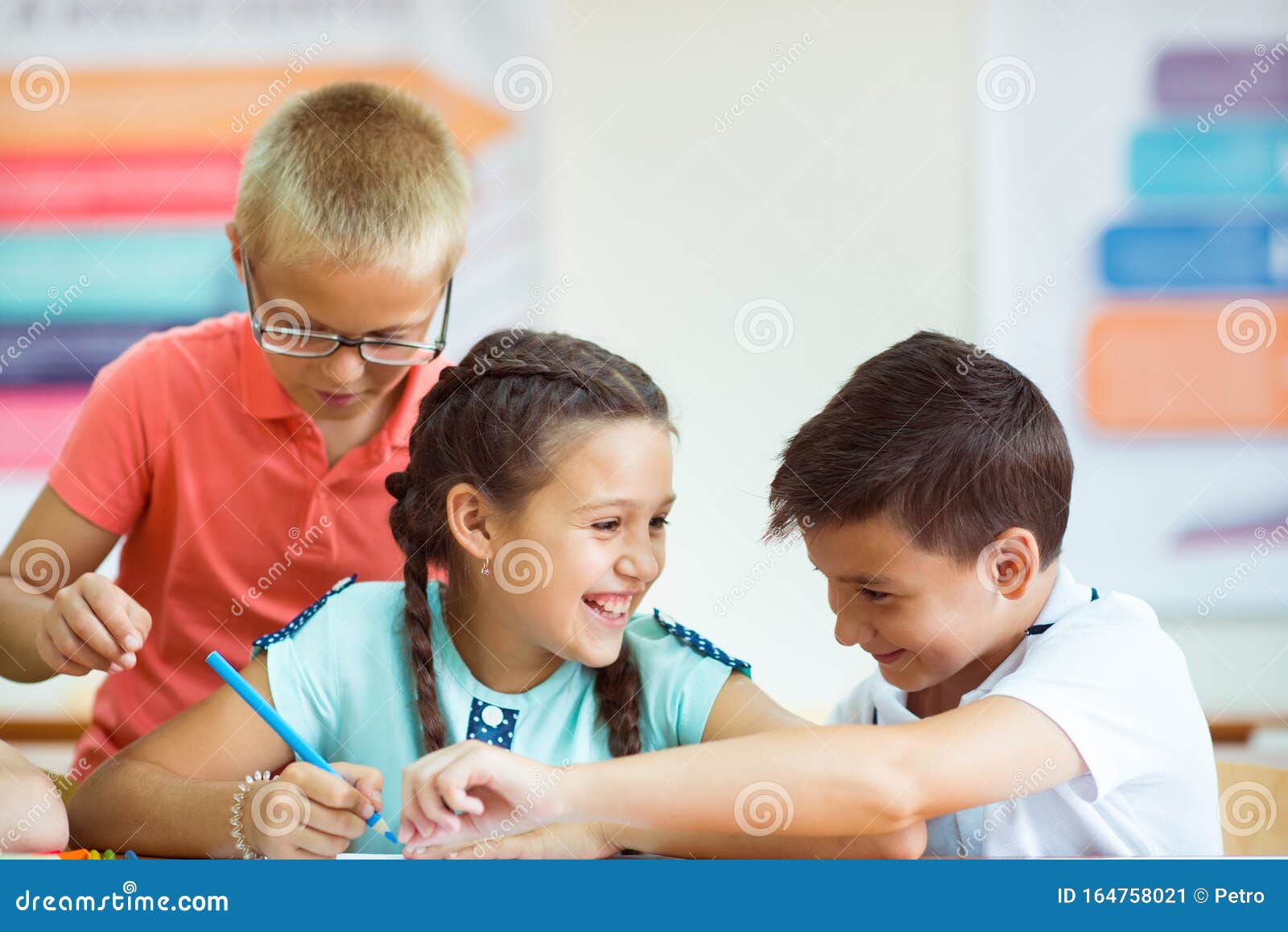 Happy Elementary Students Sitting at Desk and Joyful Discussing in ...