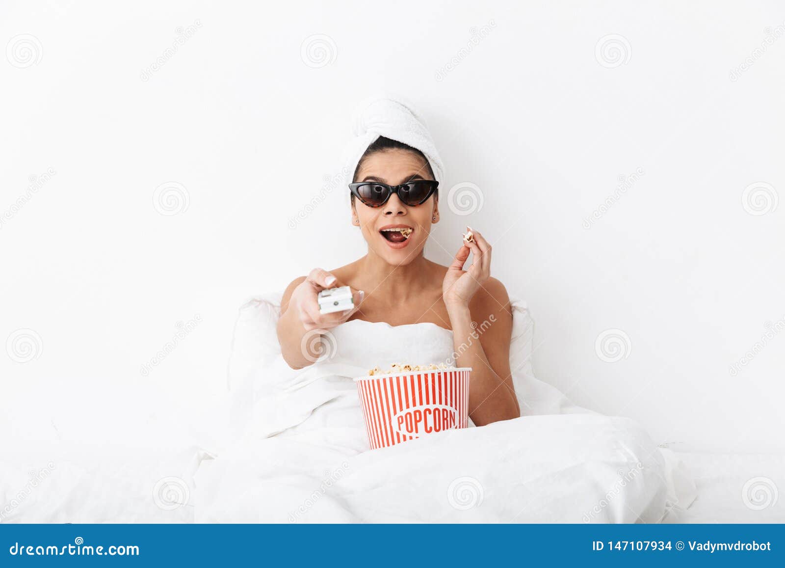 Happy Excited Woman With Towel On Head Lies In Bed Under Blanket Over