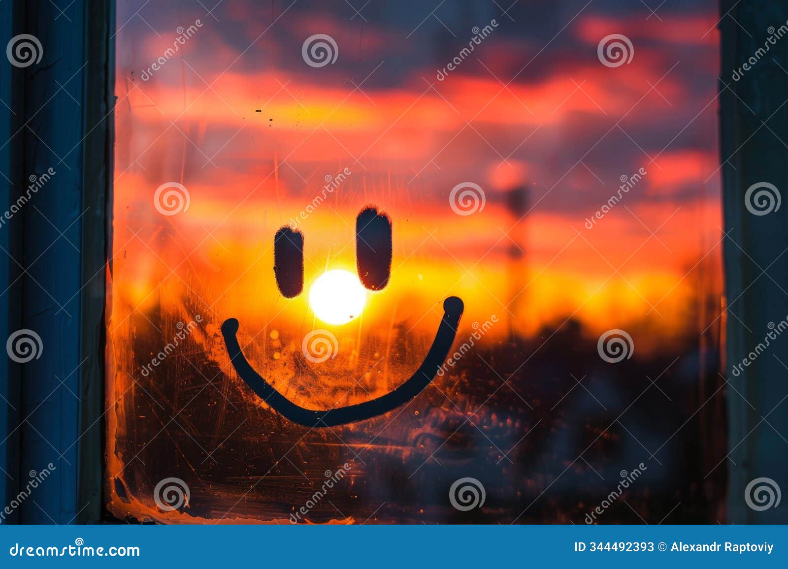 A Happy Face Drawn on a Window with an Orange Sunset in the Background ...